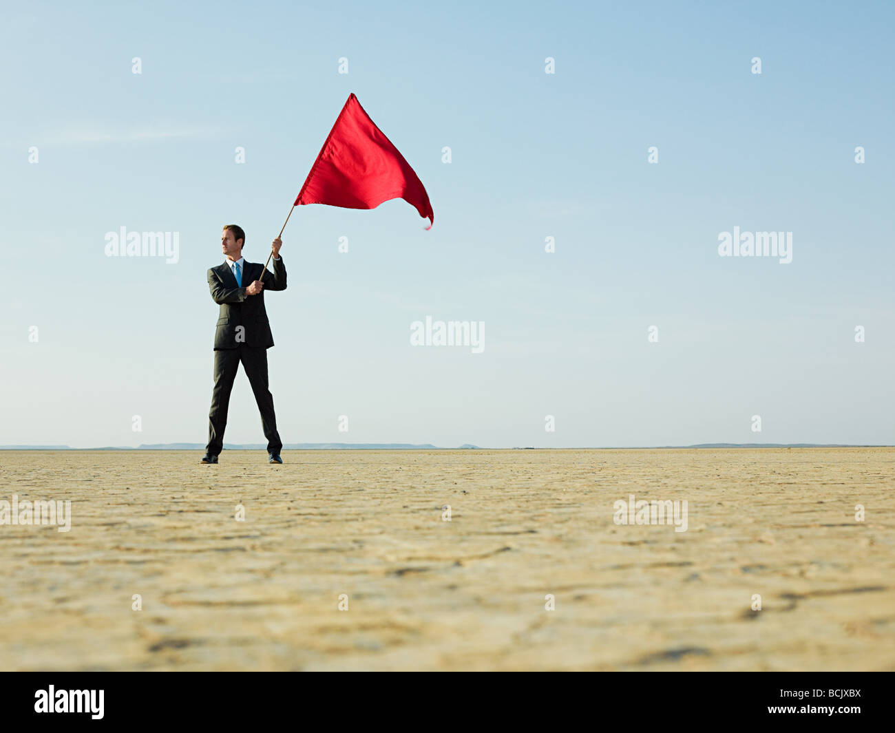 Businessman holding a red flag Stock Photo - Alamy