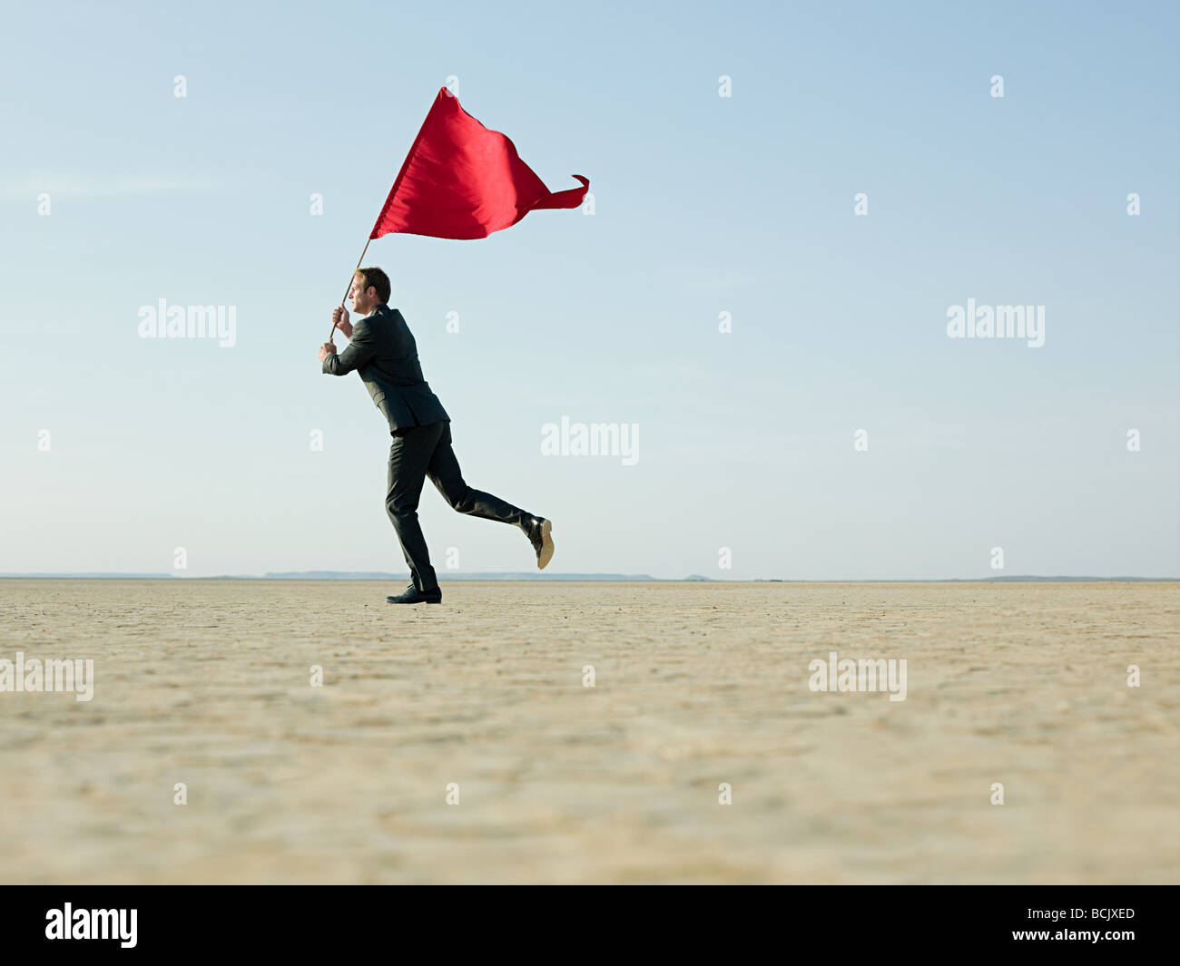 Businessman holding a red flag Stock Photo - Alamy