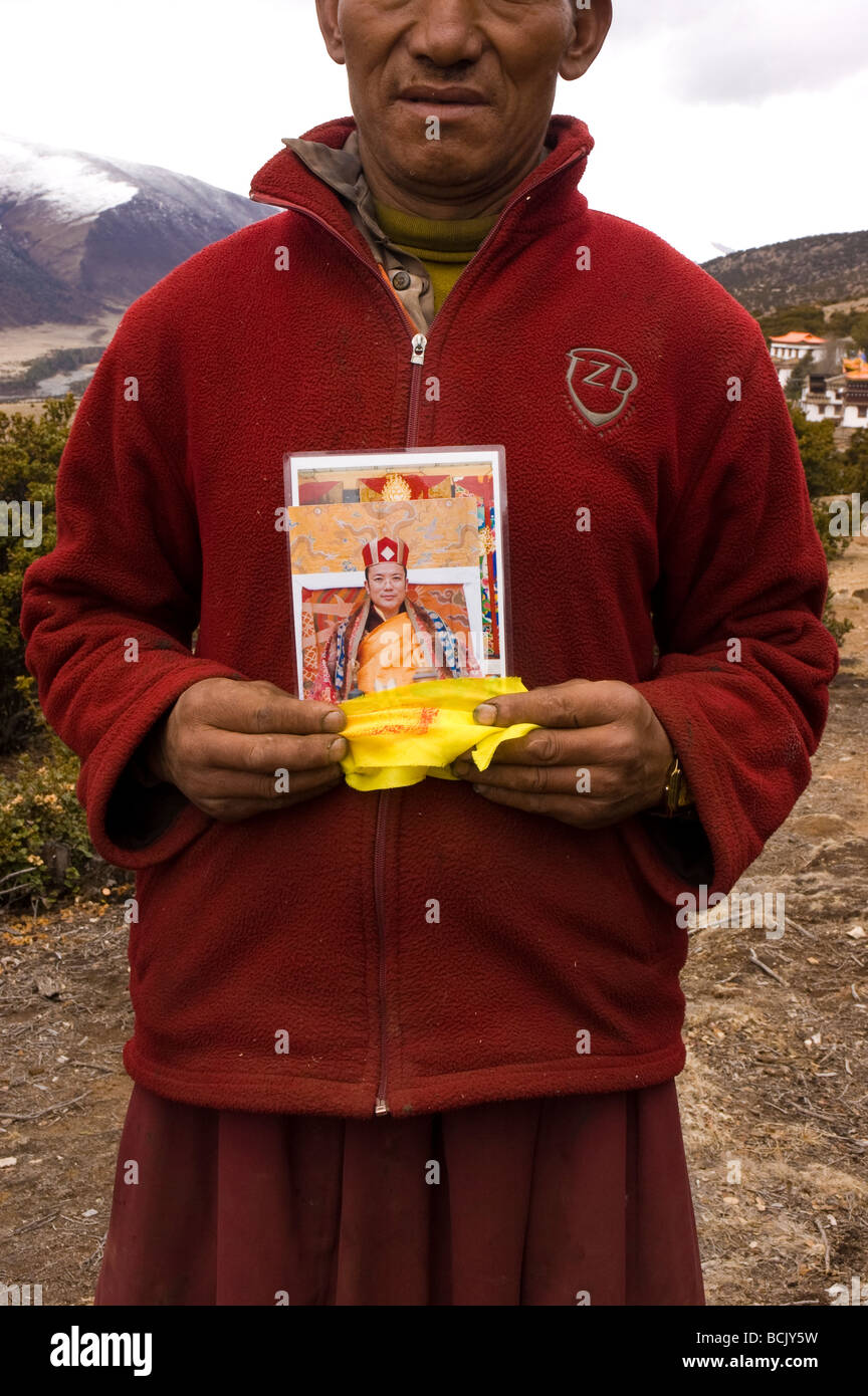 tibetan monk holding a photo of spiritual leader Stock Photo - Alamy