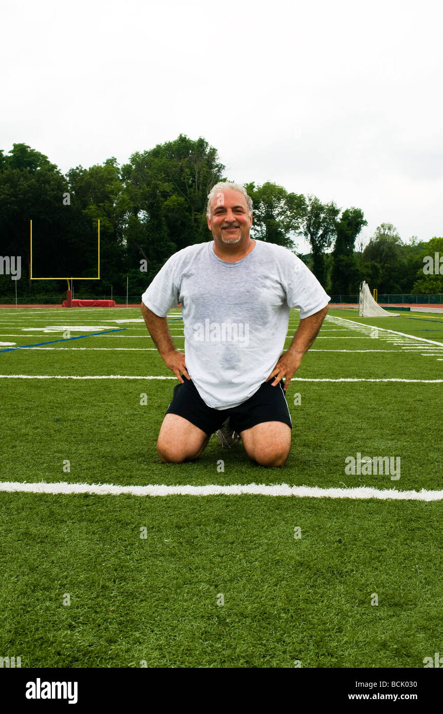 overweight middle age retired and active senior man stretching his leg ...