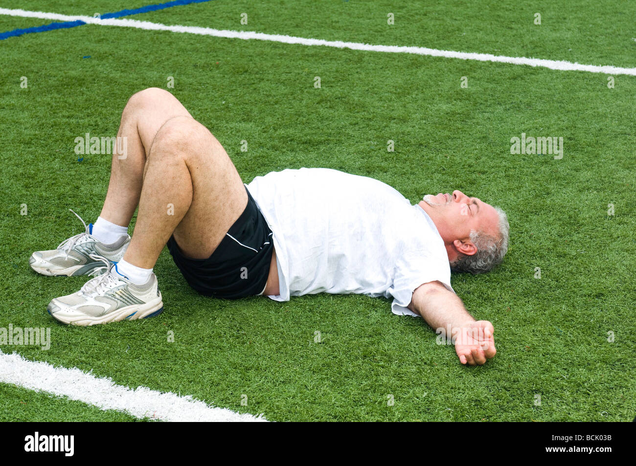 overweight middle age retired and active senior man stretching his leg ...