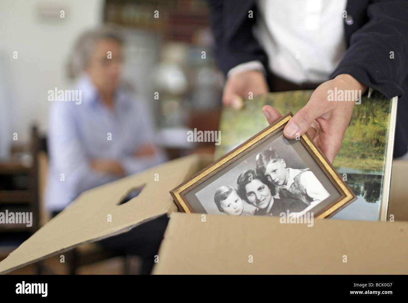 Daughter is packing her mothers packing case Stock Photo - Alamy