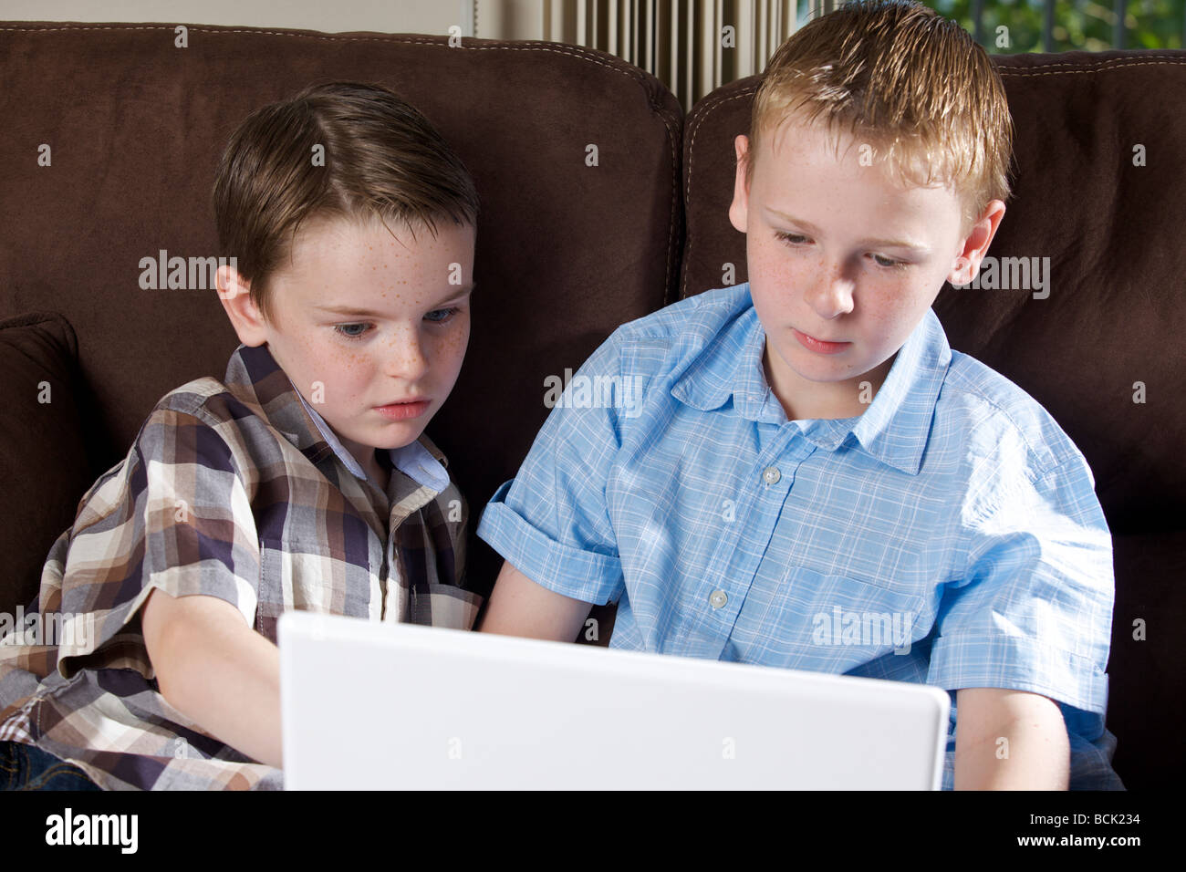 Two young boy using laptop computer at home Stock Photo - Alamy