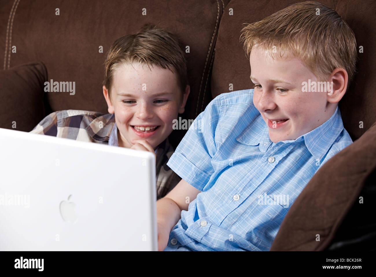 Two brothers using laptop computer at home Stock Photo - Alamy