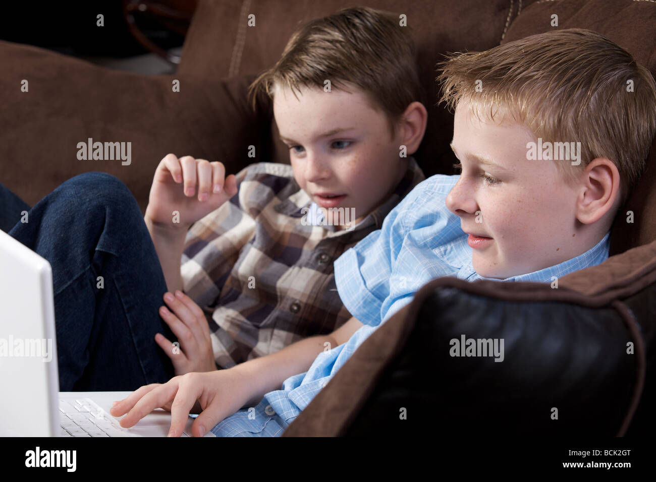 Two brothers using laptop computer at home Stock Photo - Alamy