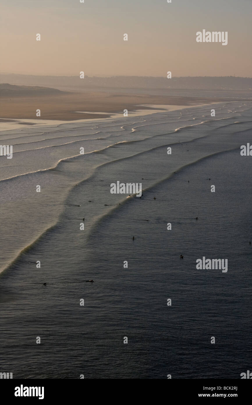 Shot of Saunton beach at dusk with people surfing Stock Photo - Alamy