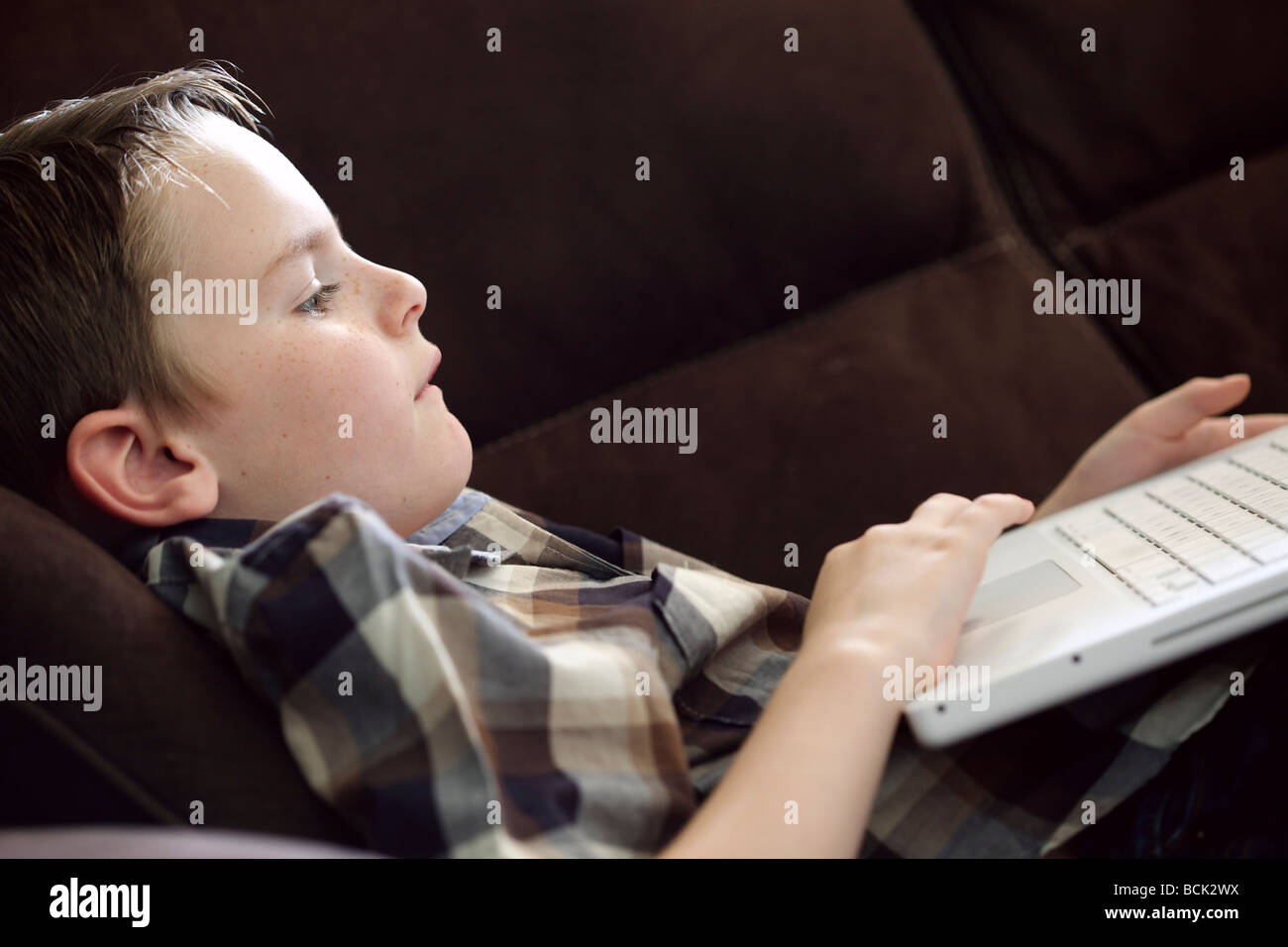 Young boy using laptop computer at home Stock Photo - Alamy