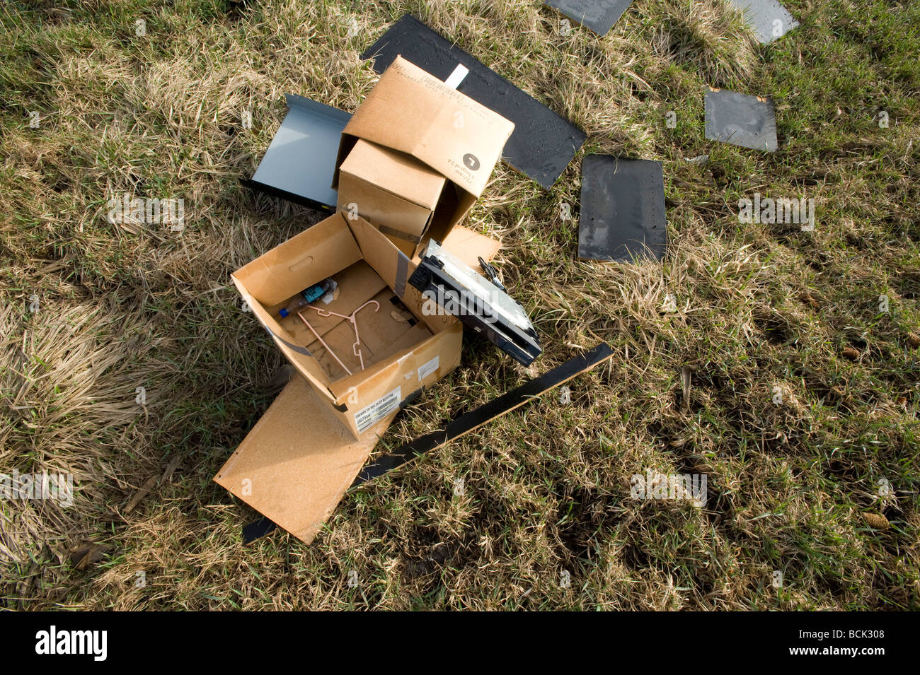 Trash dumped outside in the grass Stock Photo - Alamy