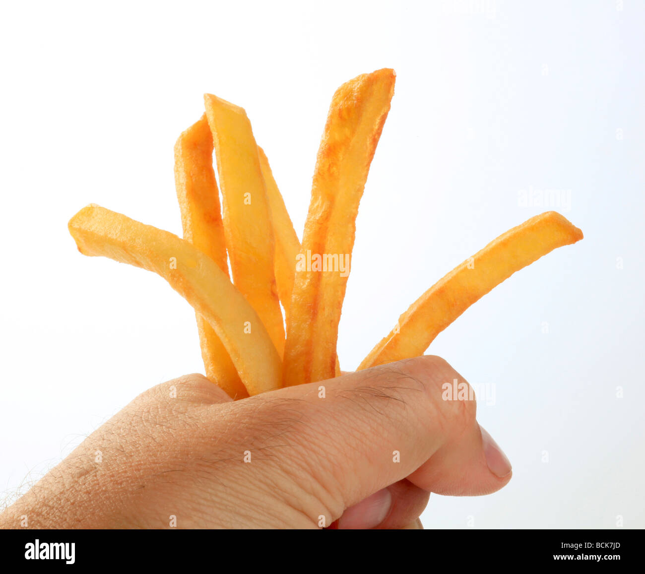 Man's hand holding French fries Stock Photo - Alamy