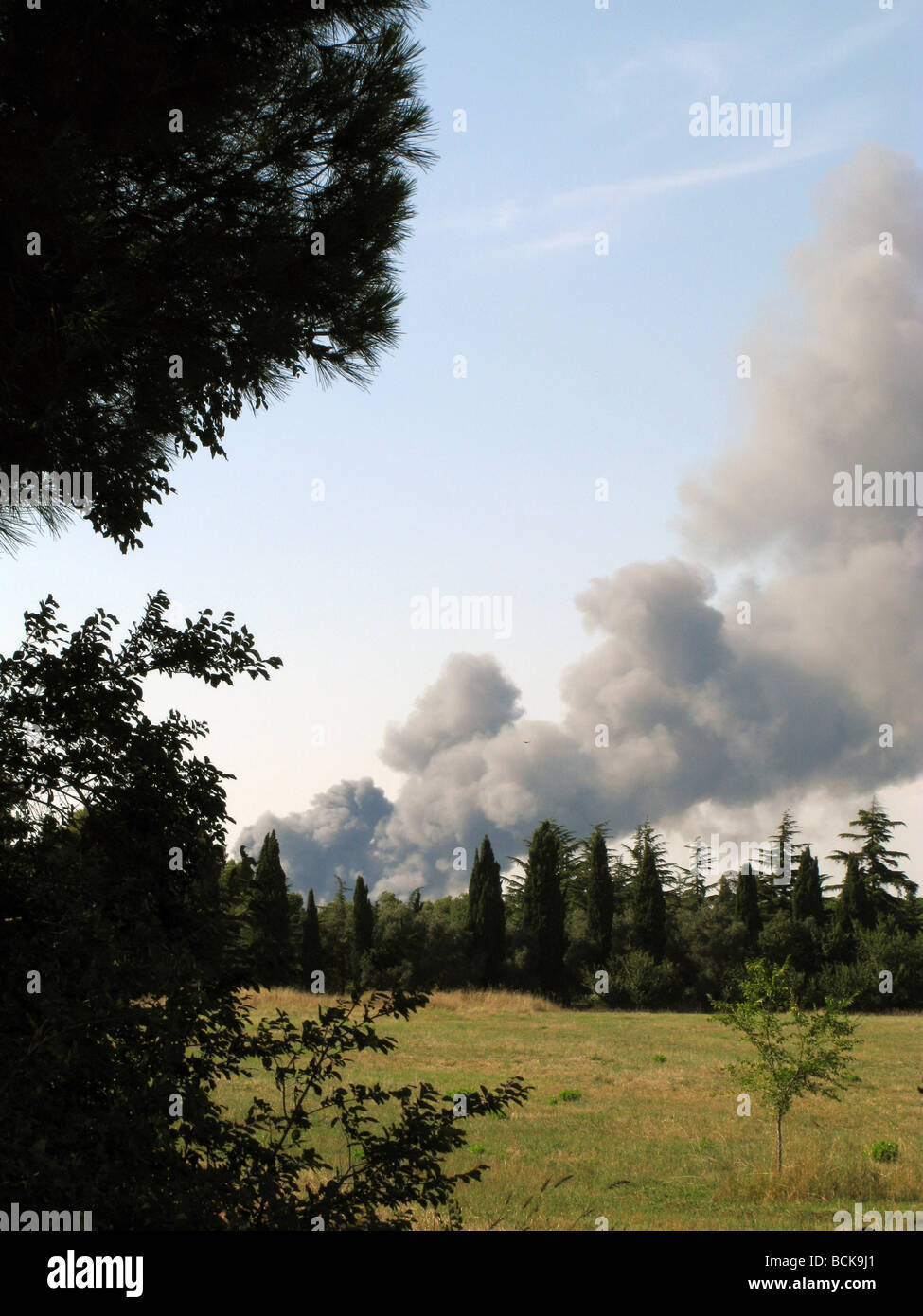 long black smoke trail over rural green landscape Stock Photo - Alamy