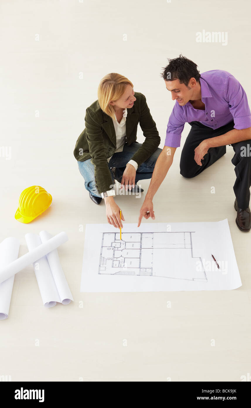 two architects looking at blueprint and smiling. High angle view Stock ...