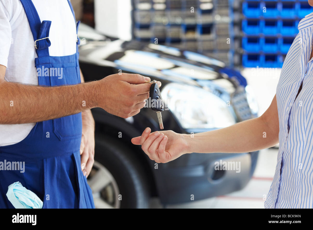 cropped view of mechanic giving car keys to female client Stock Photo ...