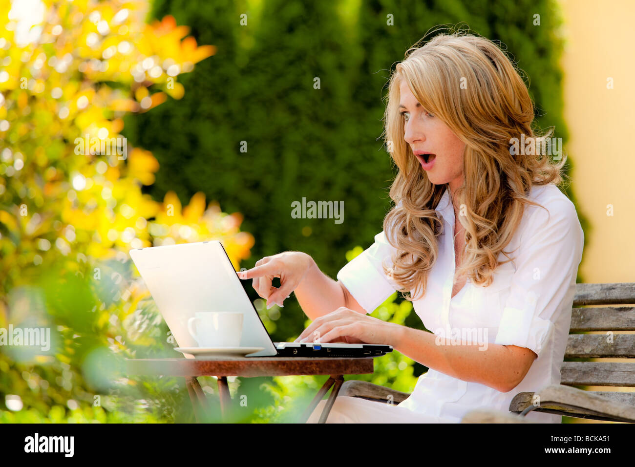 Woman with laptop in garden Stock Photo - Alamy