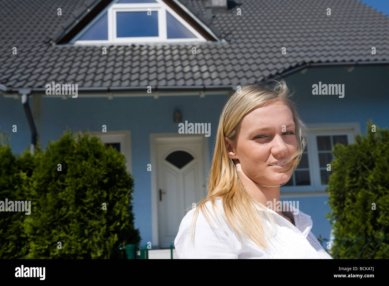 Portrait of a woman in front house Stock Photo - Alamy
