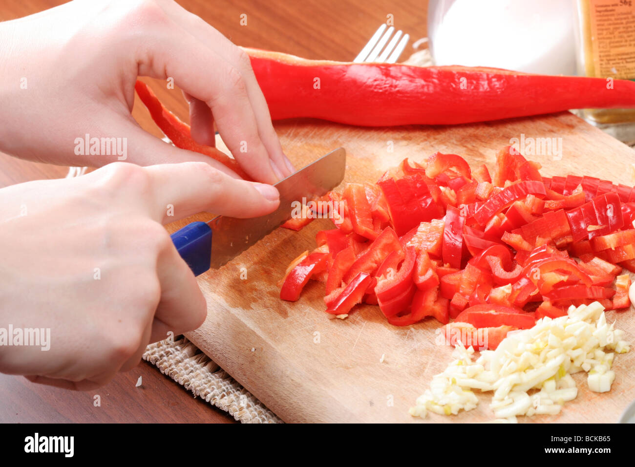 Chopping pepper with knife in small pieces Stock Photo - Alamy