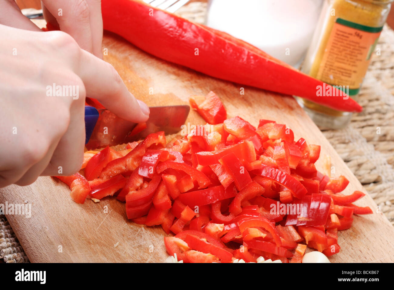 Chopping pepper with knife in small pieces Stock Photo - Alamy