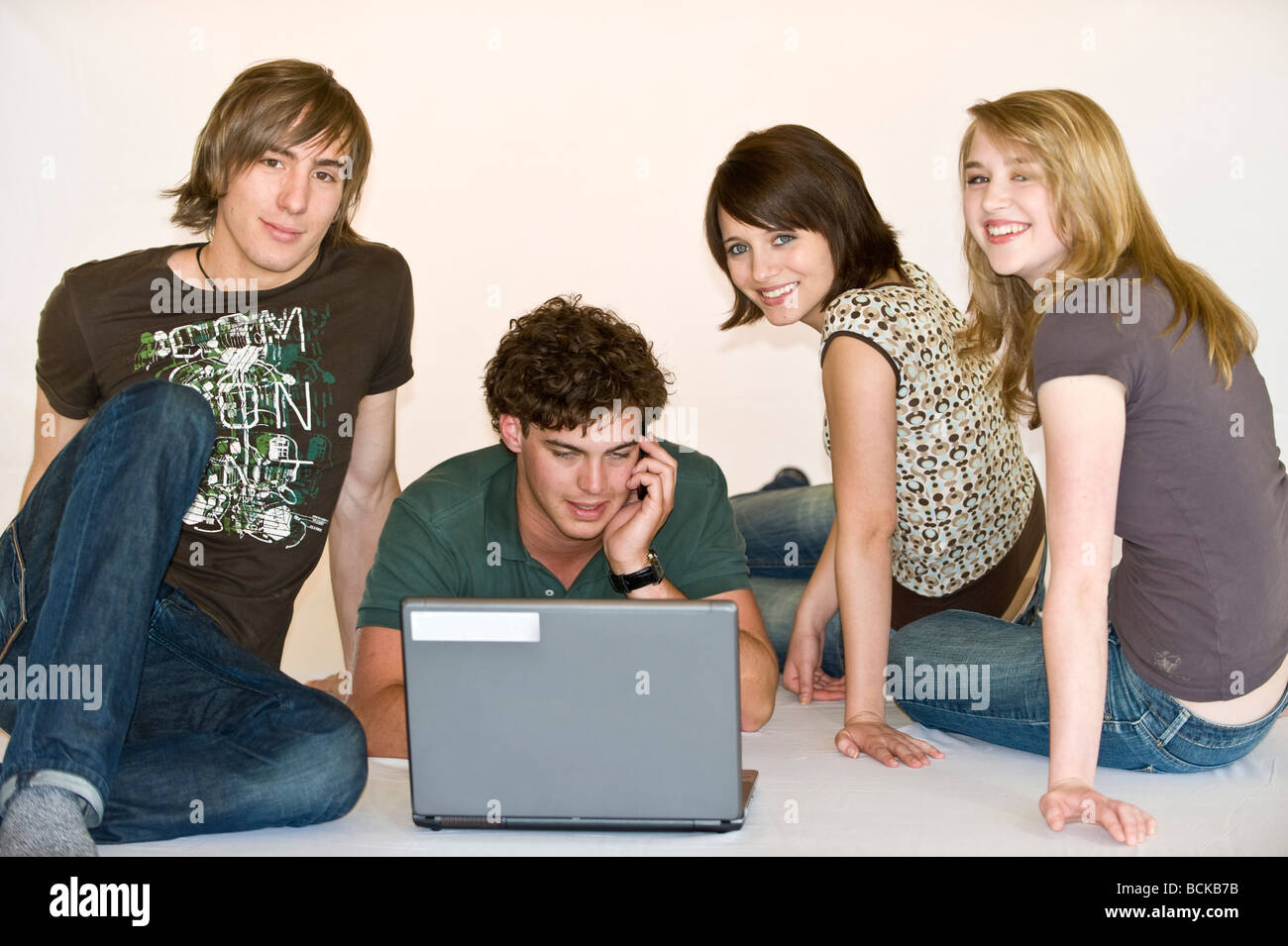 Four young people chill at the laptop Stock Photo - Alamy