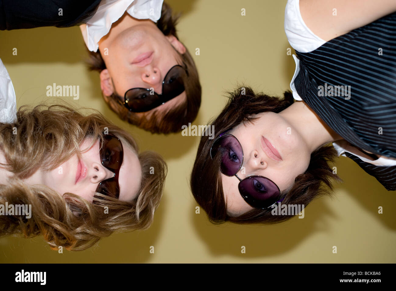 Three young people look down Stock Photo - Alamy