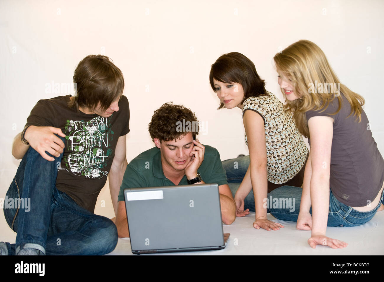 Four young people chill at the laptop Stock Photo - Alamy