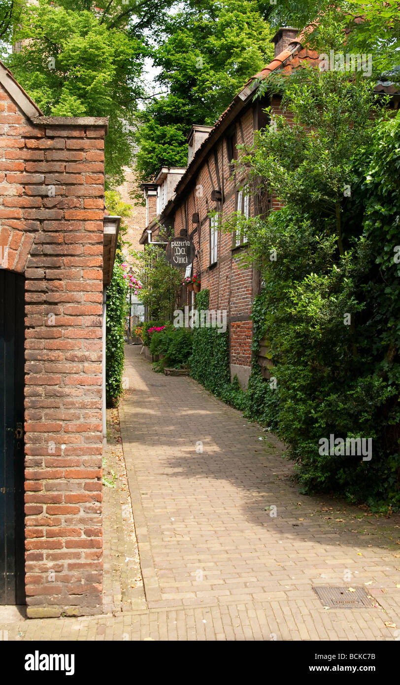 Narrow ally between red brick buildings in a typical Dutch surrounding ...