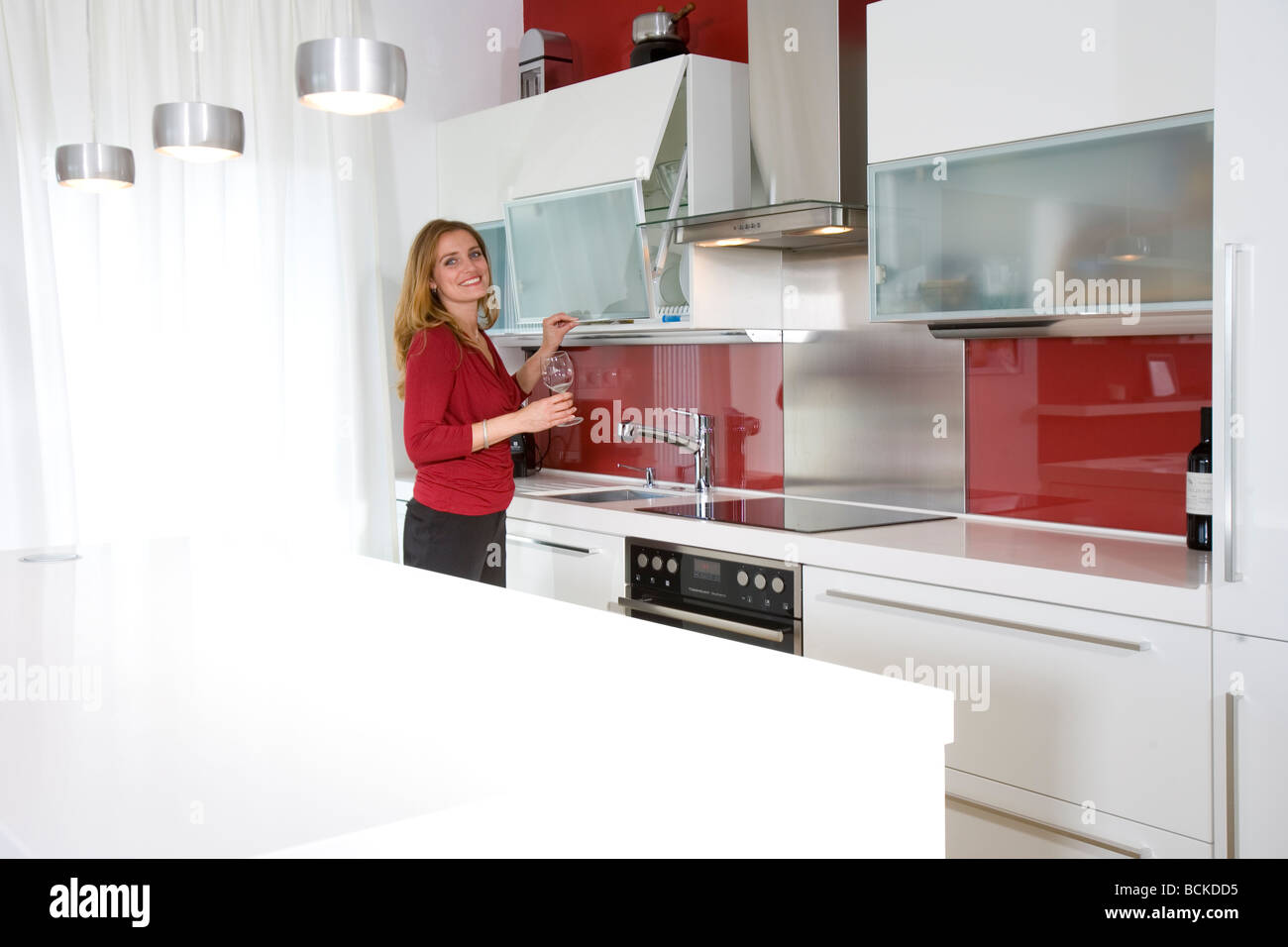 young beautiful woman standing in modern kitchen interior Stock Photo ...
