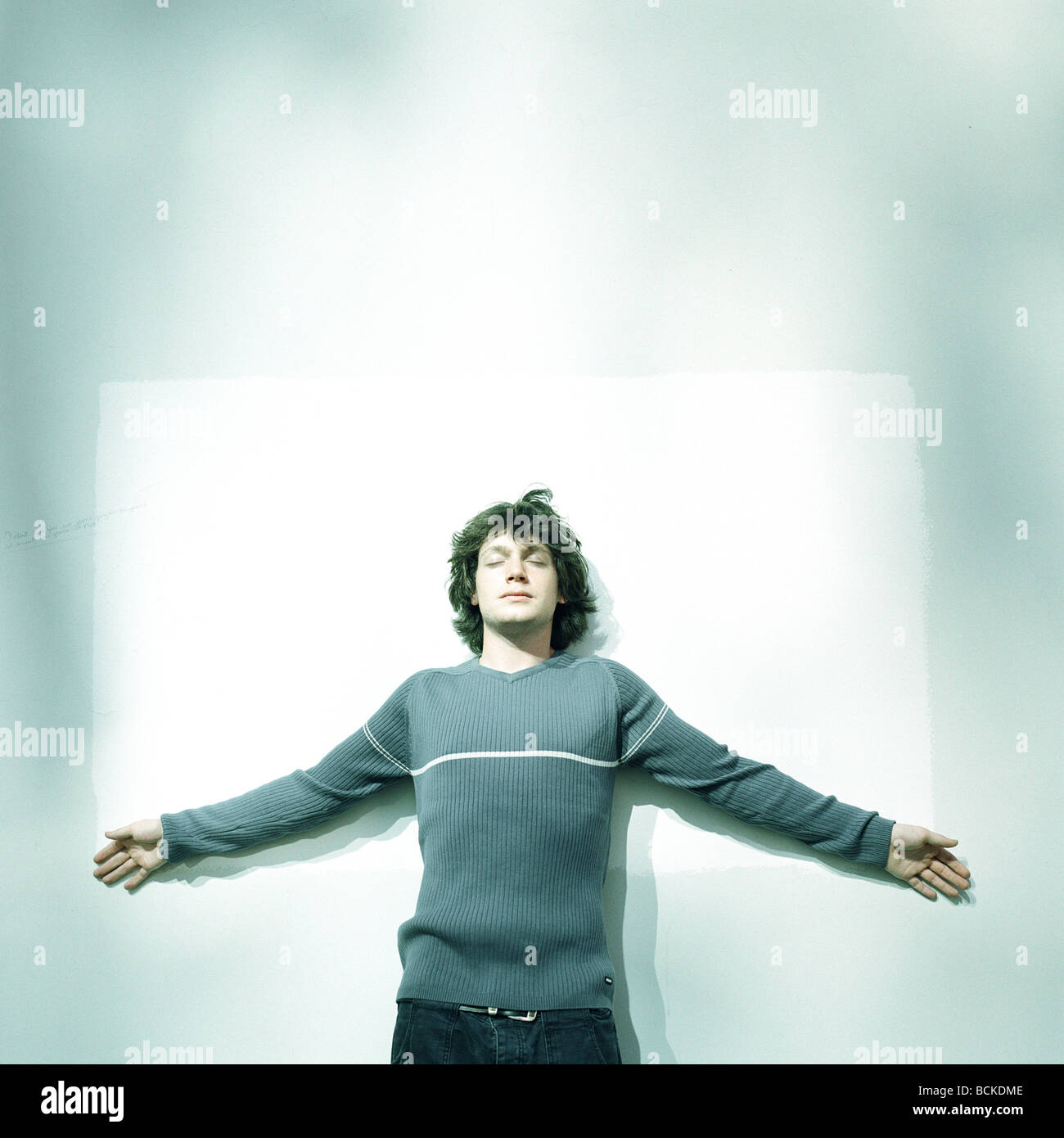 Young man with arms out and eyes closed Stock Photo - Alamy