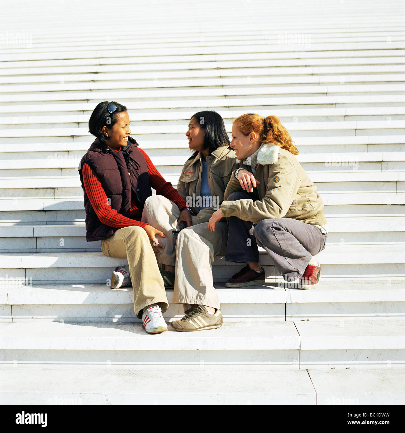 Young women sitting on steps Stock Photo - Alamy
