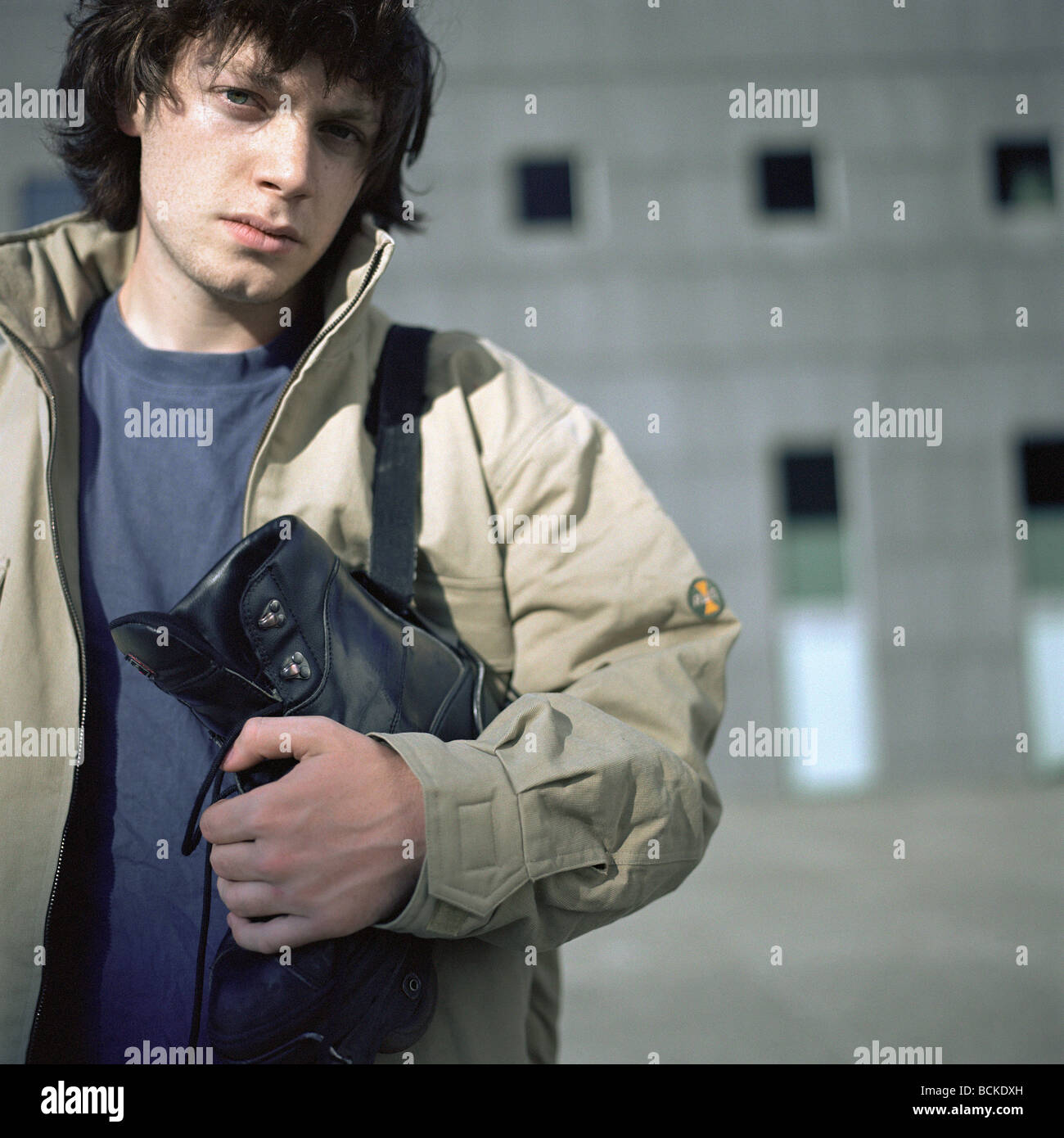 Urban scene, young man holding in-line skate Stock Photo - Alamy
