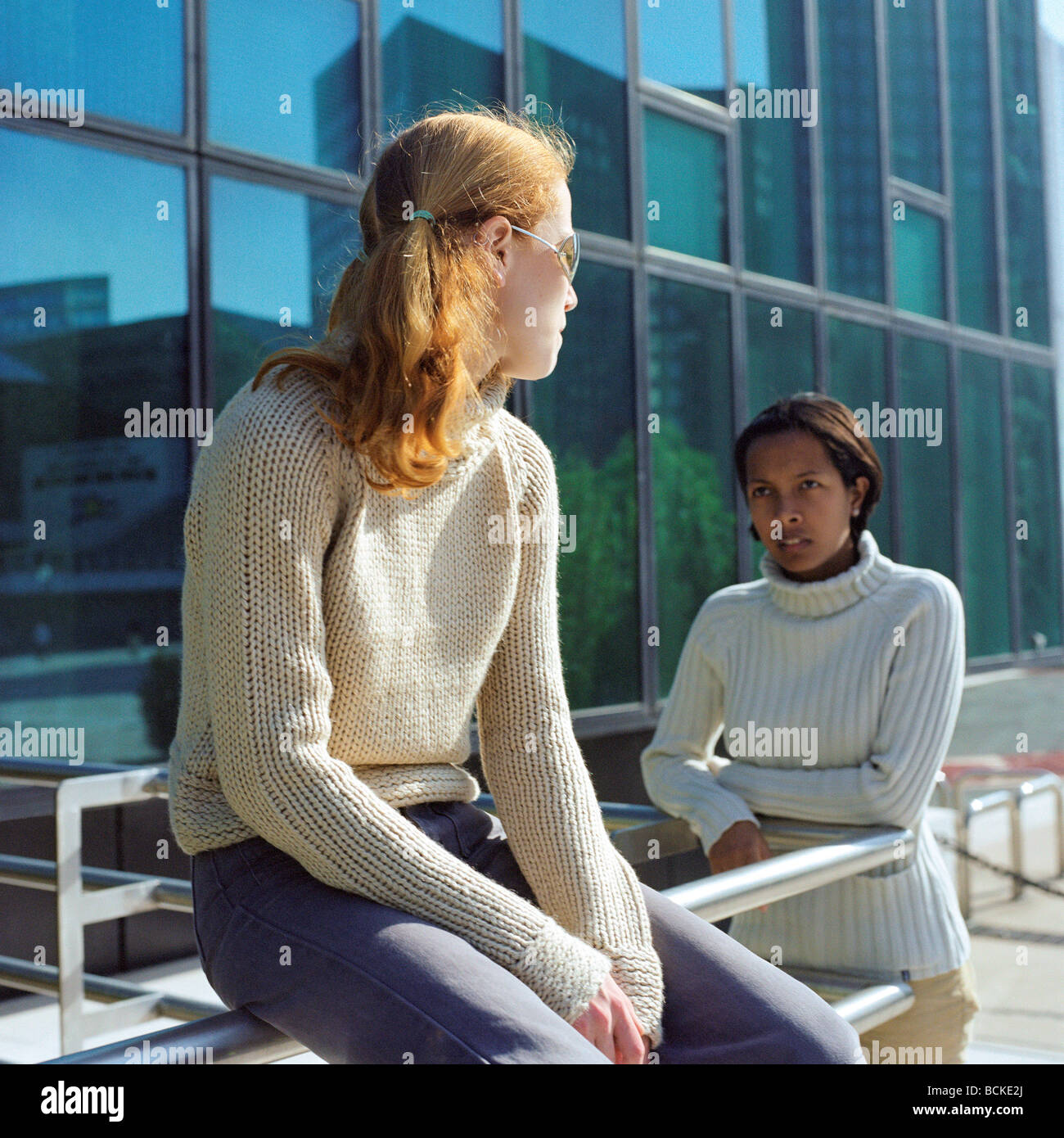Urban scene, young women talking Stock Photo - Alamy