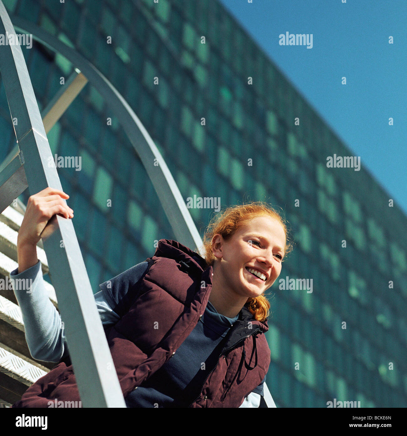 Young woman on ladder, low angle view Stock Photo - Alamy