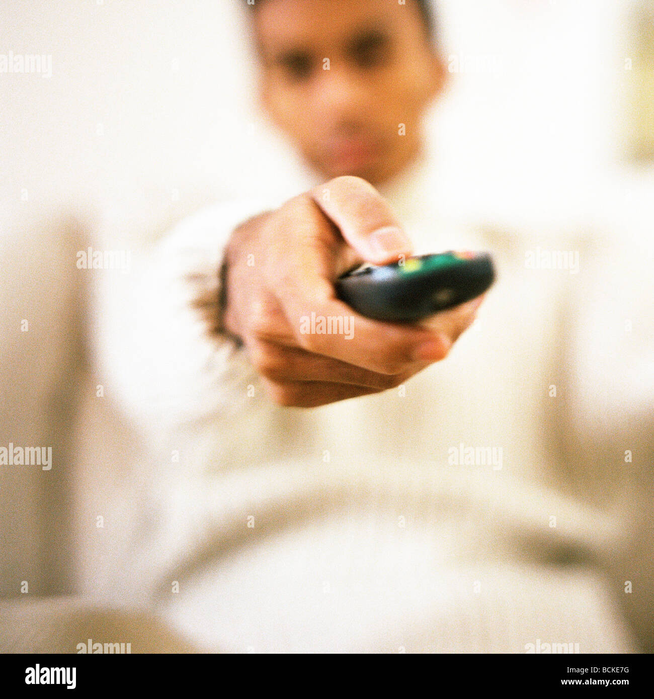 Young man holding remote control Stock Photo - Alamy