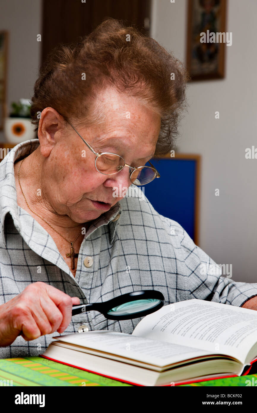 Old Woman with glasses reading a book Stock Photo - Alamy