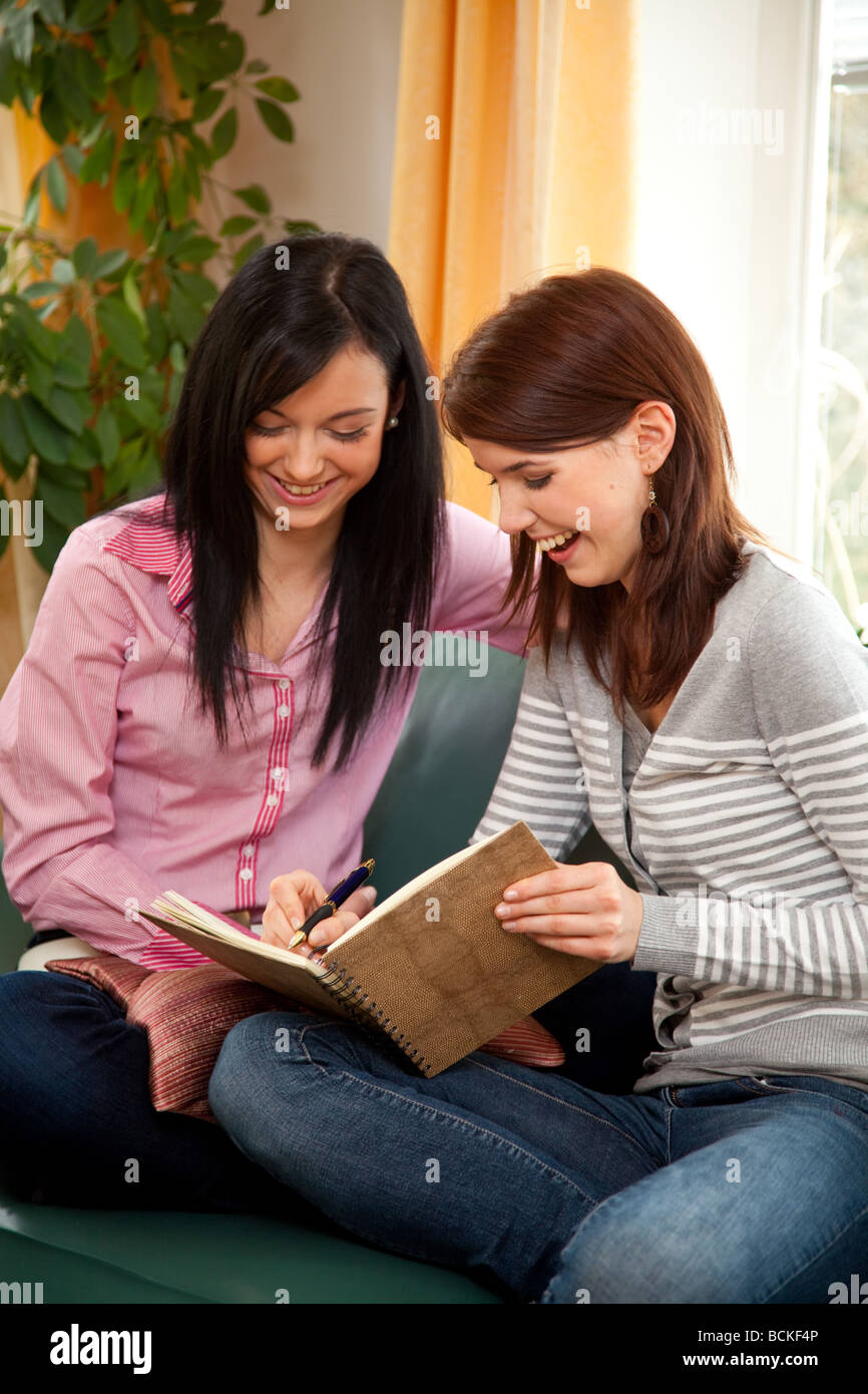Two young women write down their thoughts in a diary Stock Photo - Alamy
