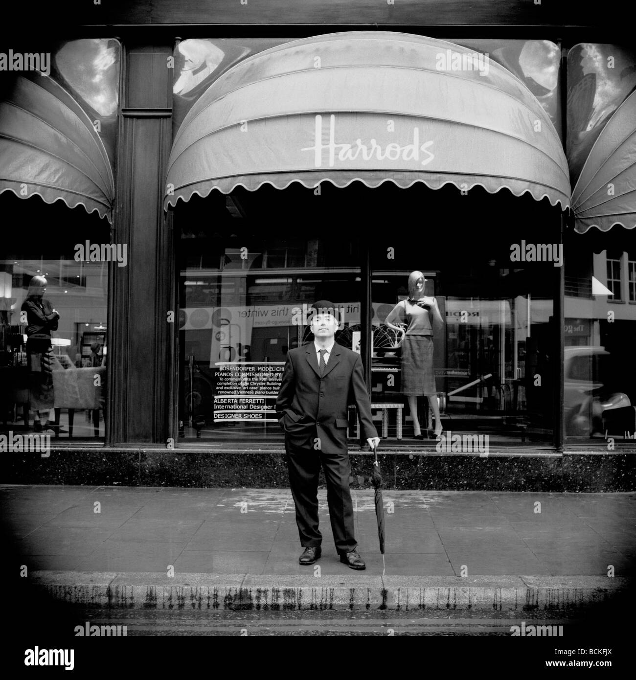 Traditional British city gentleman with bowler hat and umbrella outside ...
