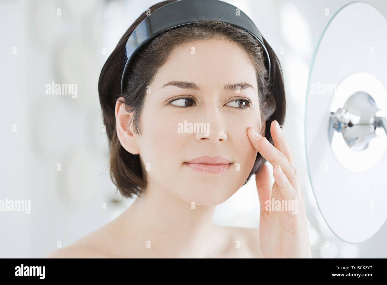 Woman looking in mirror Stock Photo - Alamy