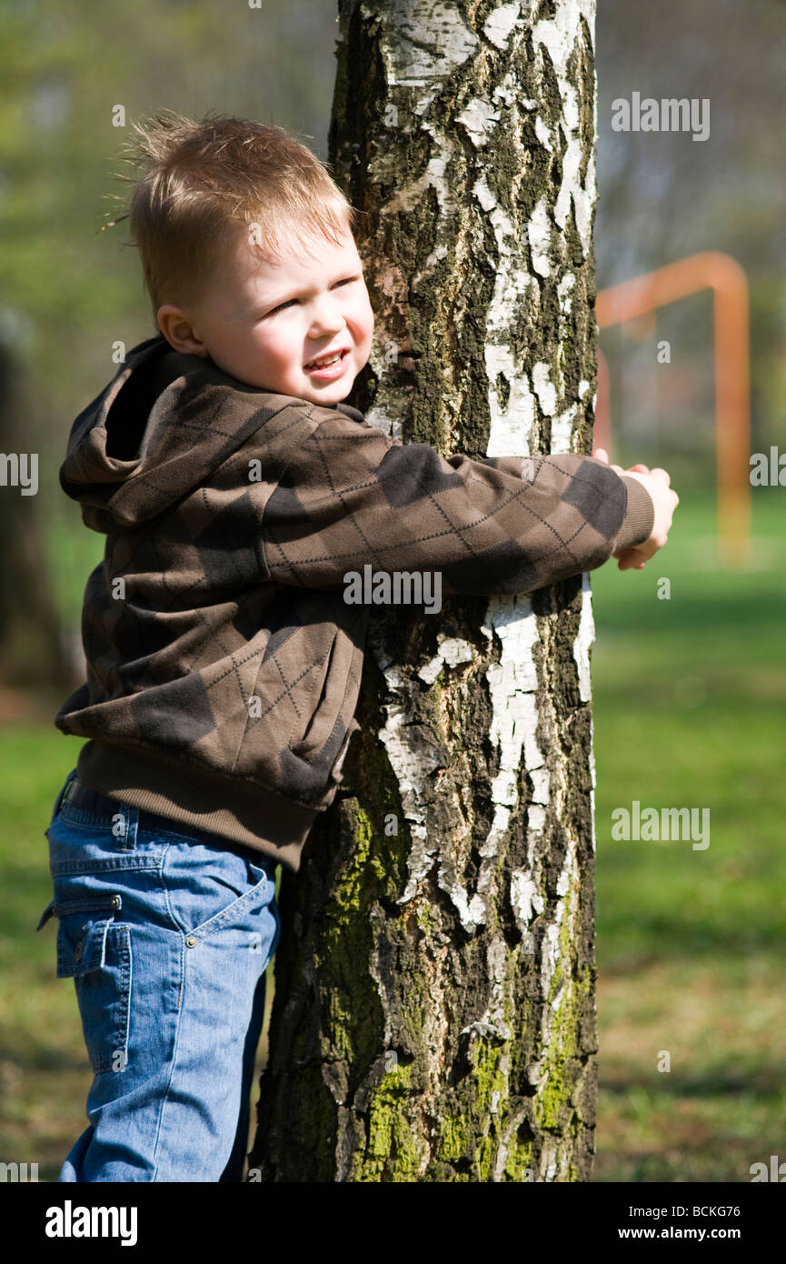 Boy hugging tree Stock Photo - Alamy