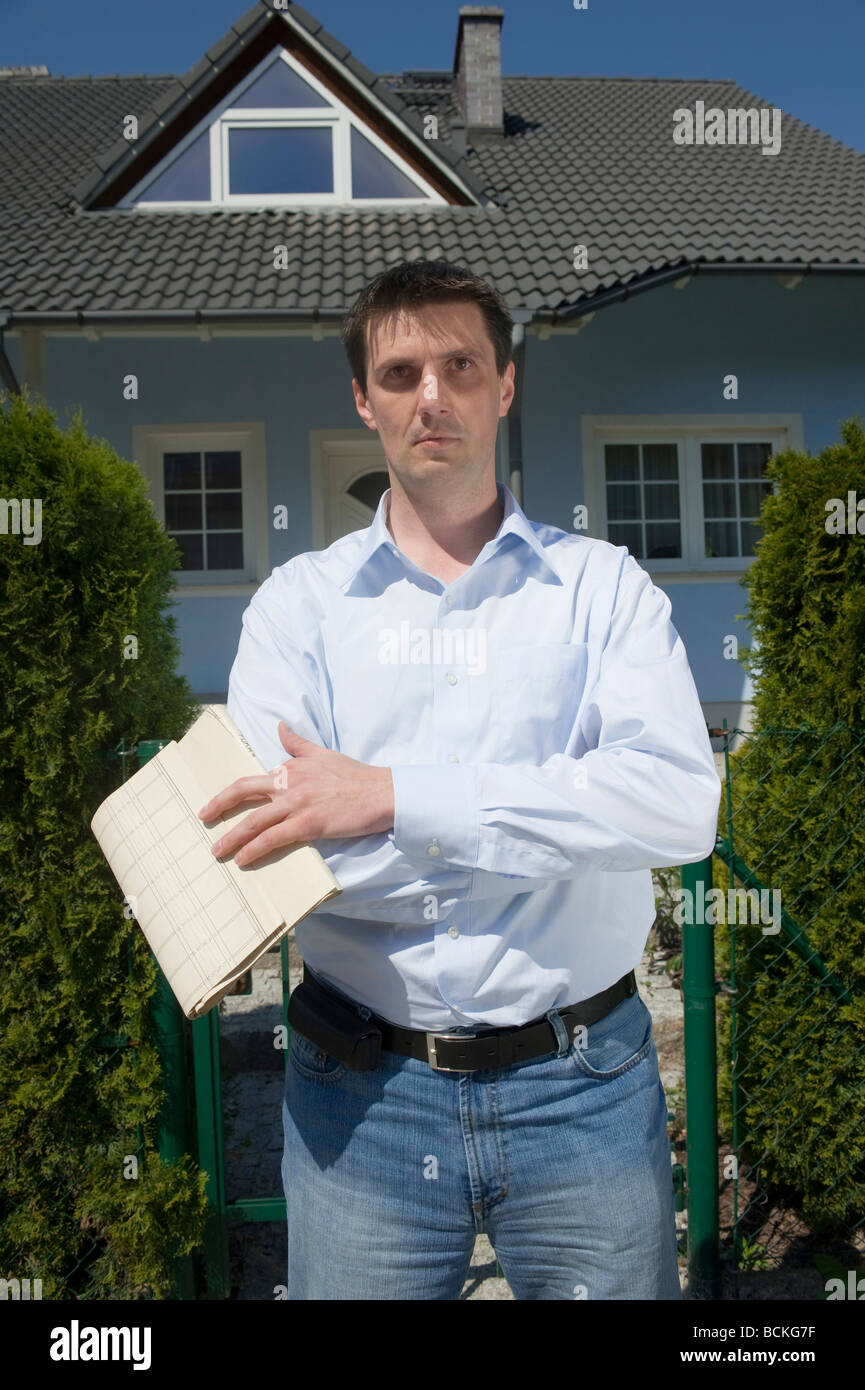Man with building plans in front of house Stock Photo - Alamy