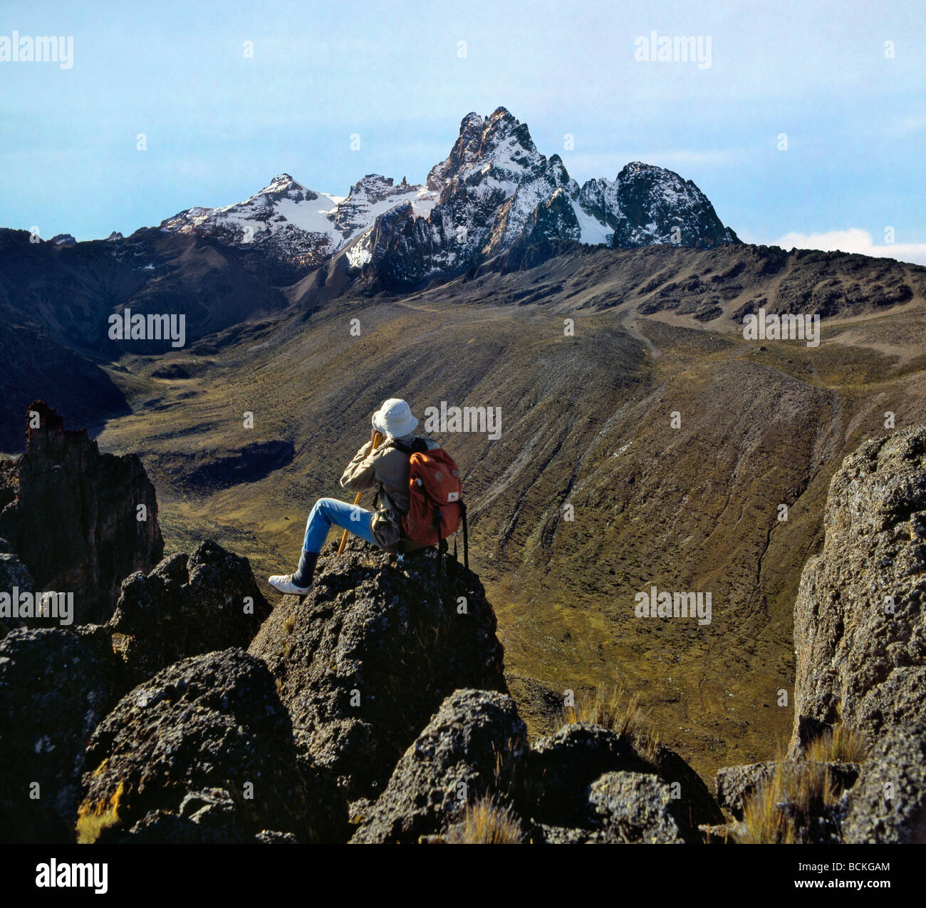 Kenya. A climber pauses to view the snow-capped peaks of Mount Kenya ...
