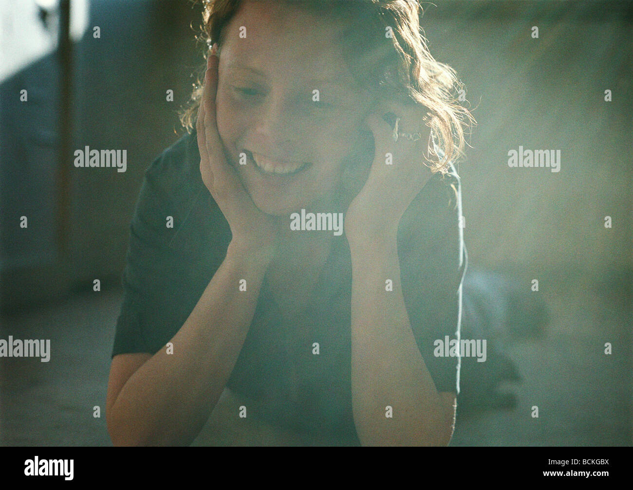 Young woman using cell phone, hand on side of face Stock Photo - Alamy