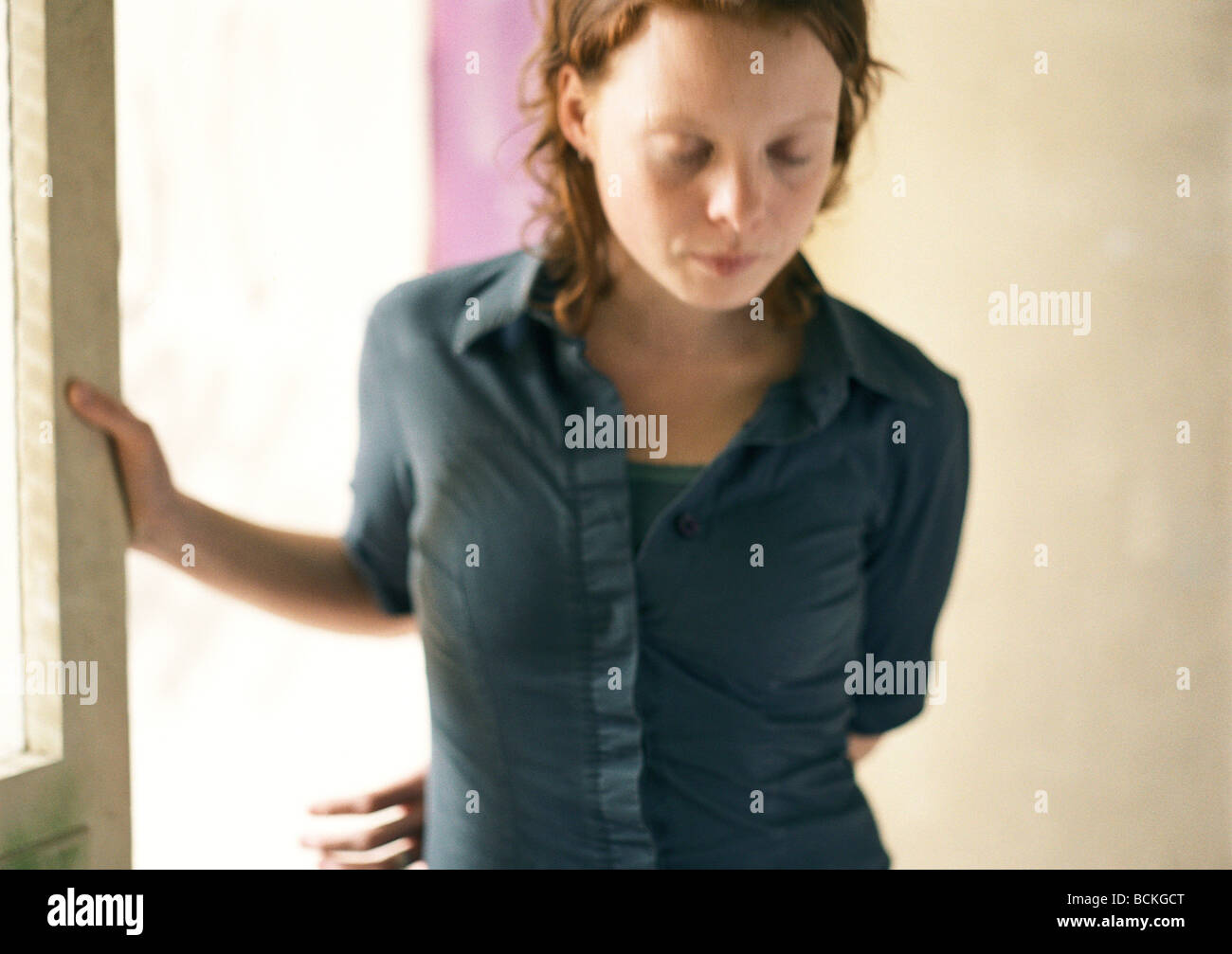 Young woman holding edge of door, eyes closed Stock Photo - Alamy