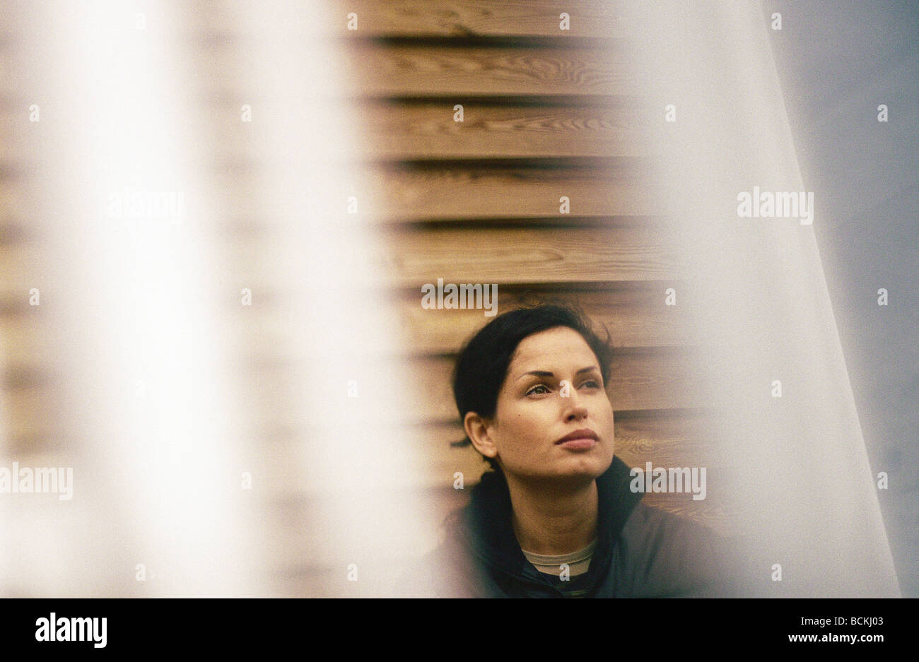Woman in front of wooden paneling, blurred foreground Stock Photo - Alamy
