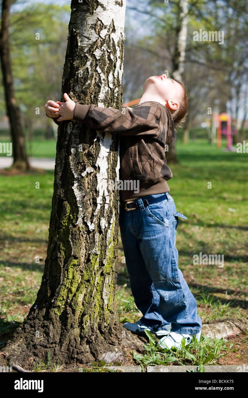 Boy hugging tree Stock Photo - Alamy