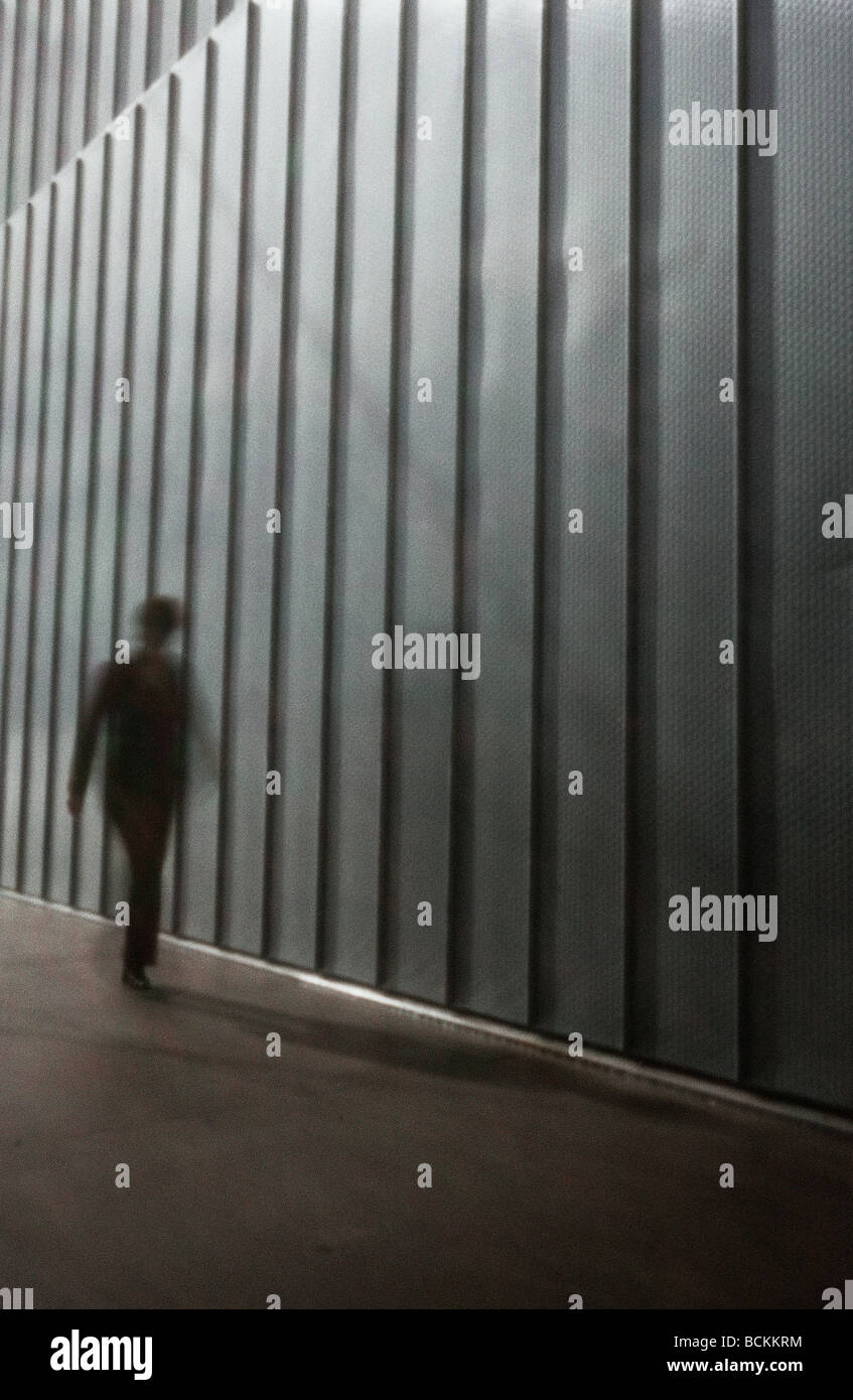 Person walking along wall Stock Photo - Alamy