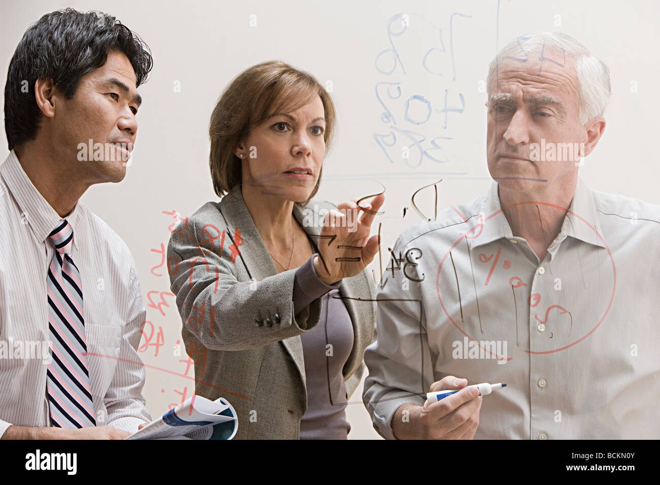 People looking at diagram on glass wall Stock Photo - Alamy
