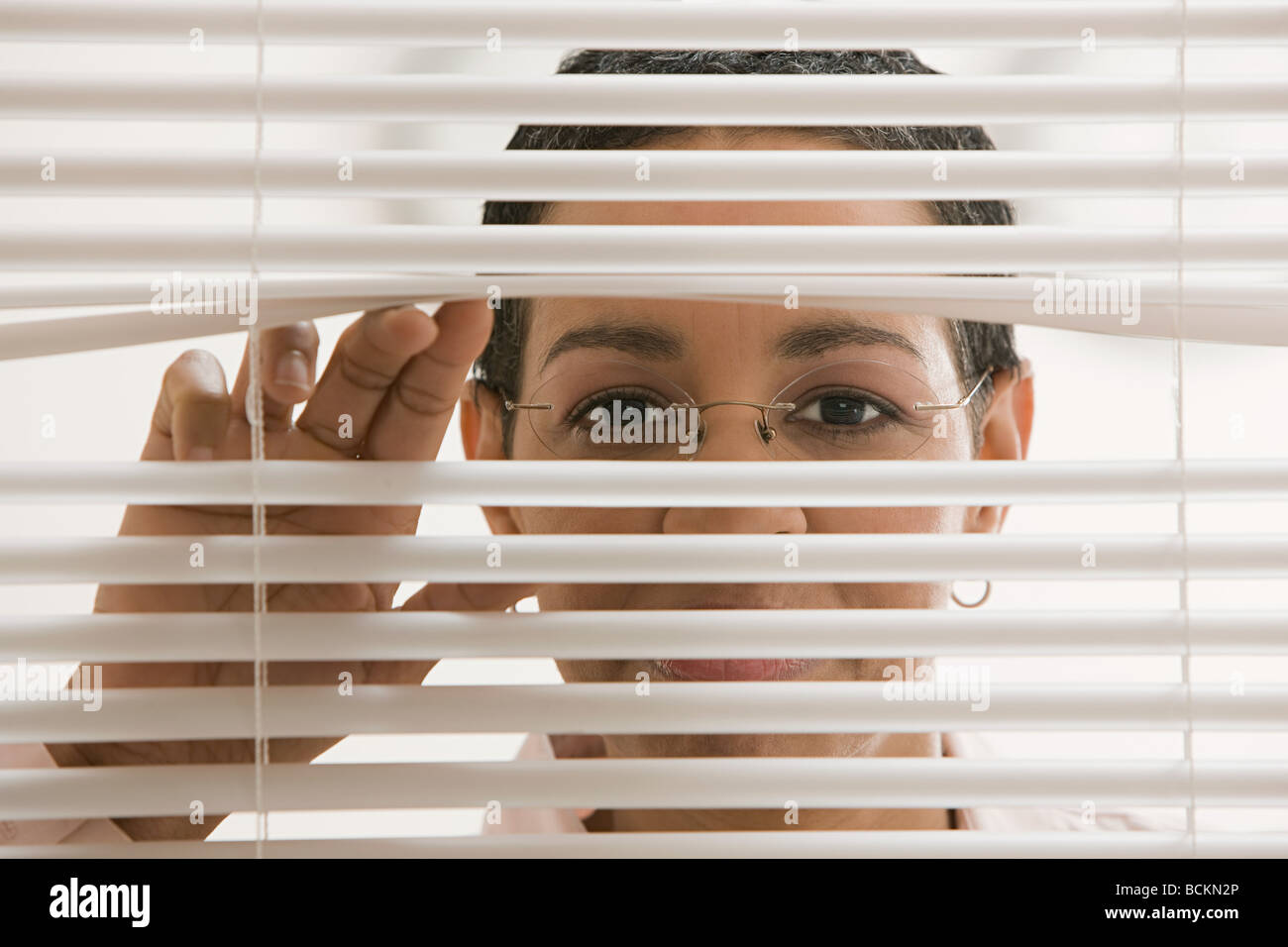 Mature woman looking through blinds hi-res stock photography and images ...