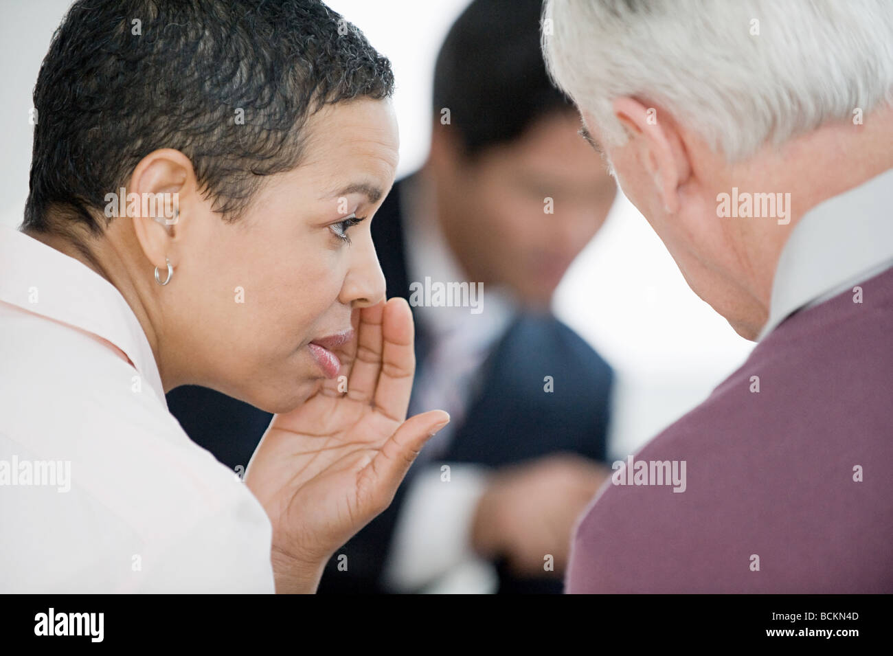 Woman whispering in meeting Stock Photo - Alamy