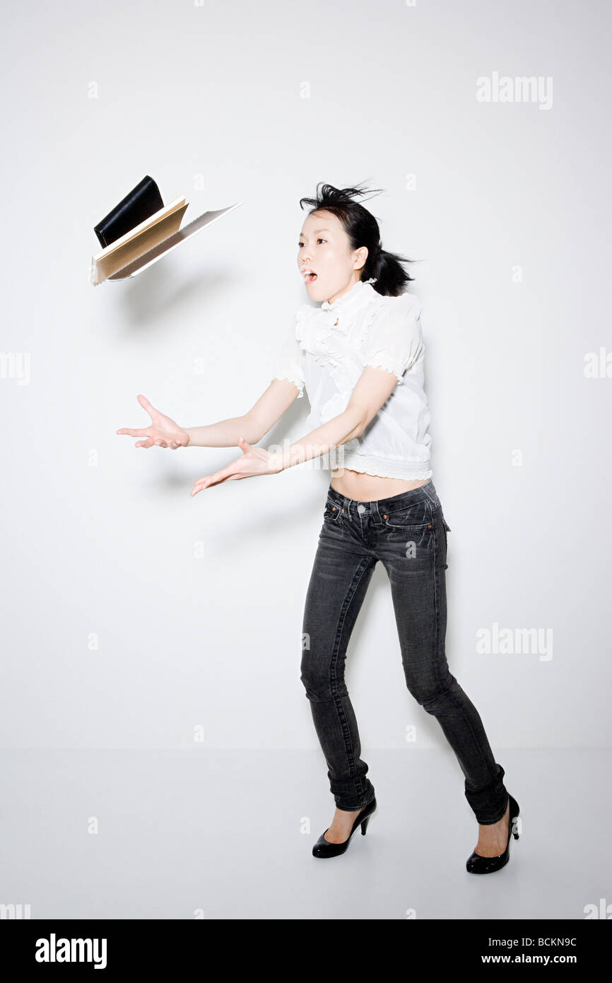 Woman throwing books Stock Photo - Alamy
