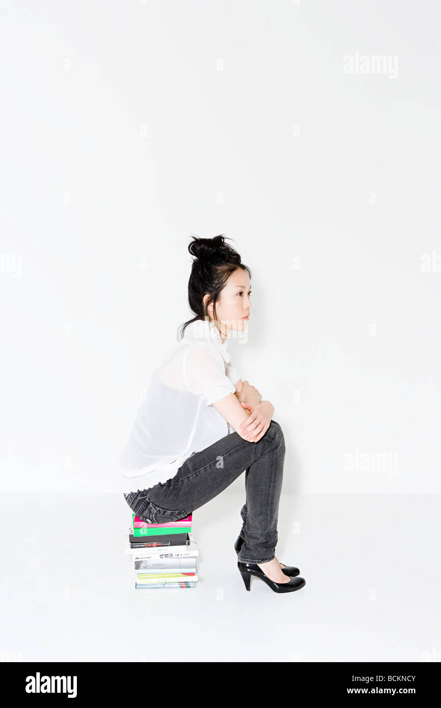 Woman Sitting On Stack Books High Resolution Stock Photography and ...