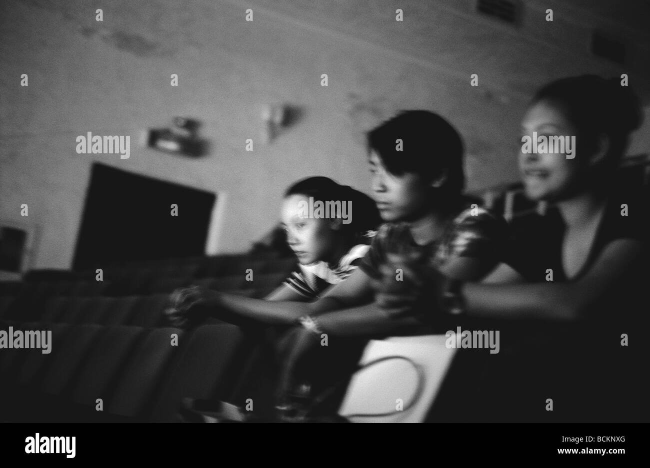 Three young people sitting in movie theater, b&w Stock Photo - Alamy