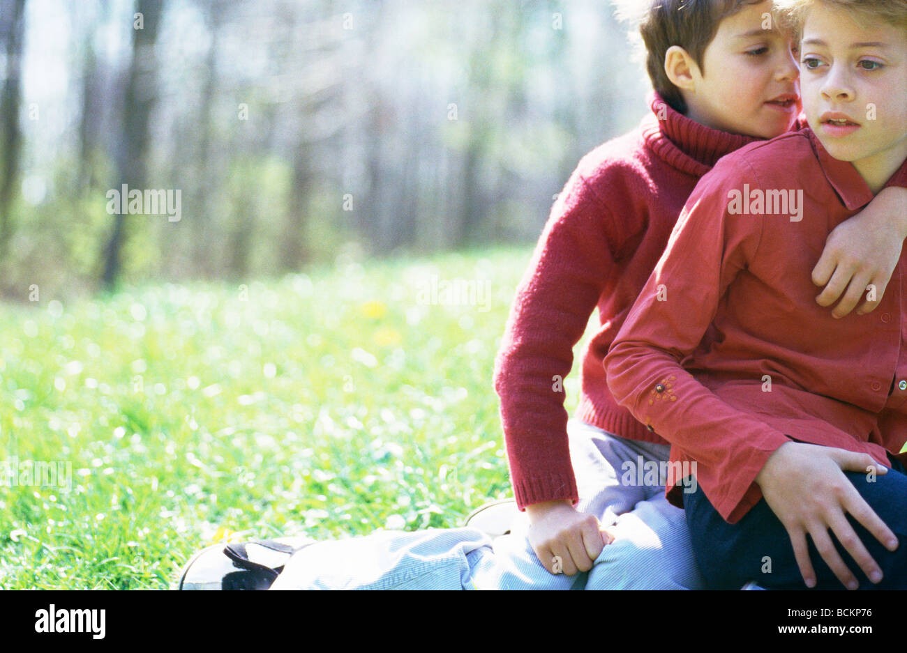 Two children sitting on grass together Stock Photo - Alamy